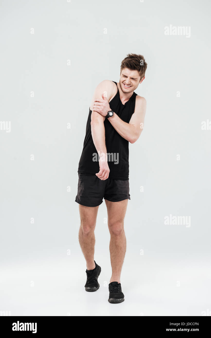 Image of sad young sportsman standing isolated over white background ...