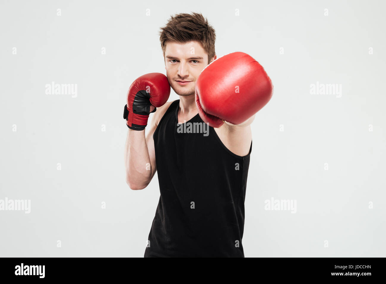 Picture of concentrated young sportsman boxer standing isolated over ...