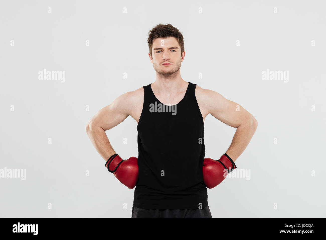 Picture of concentrated young sportsman boxer standing isolated over ...