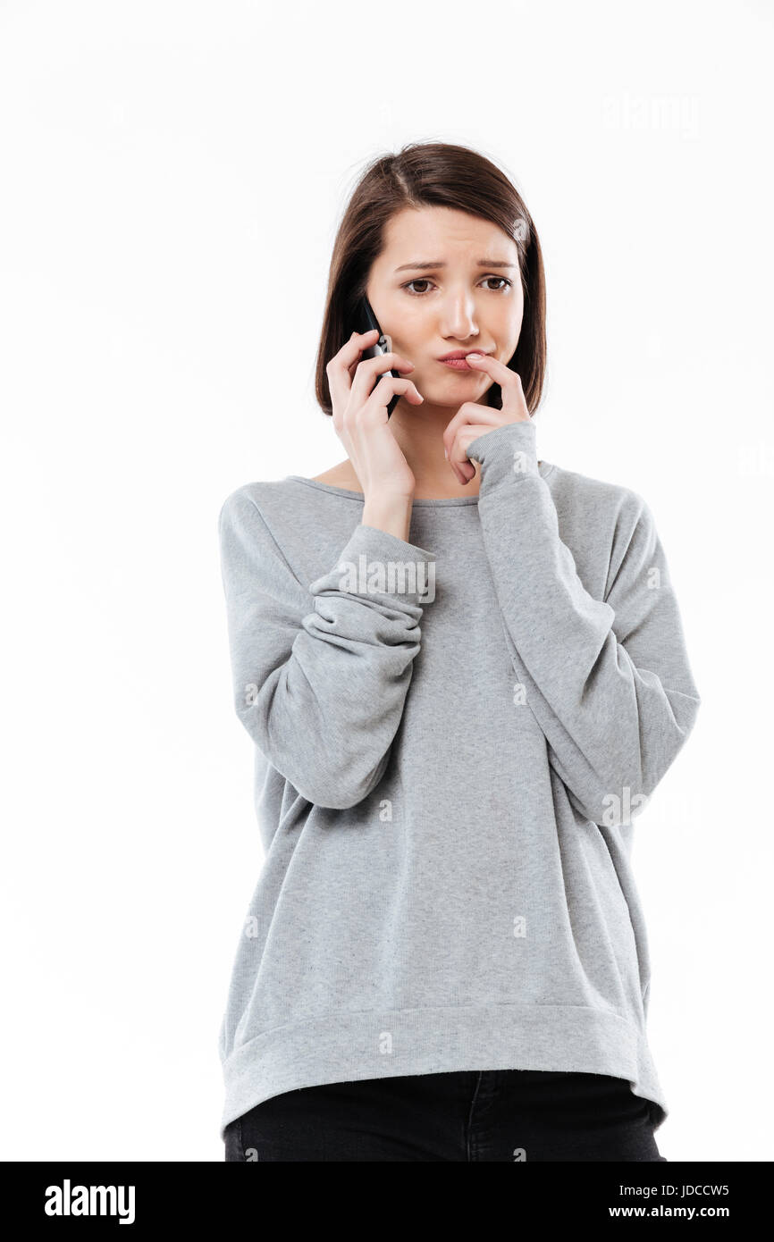 Picture of sad young caucasian woman standing isolated over white wall ...