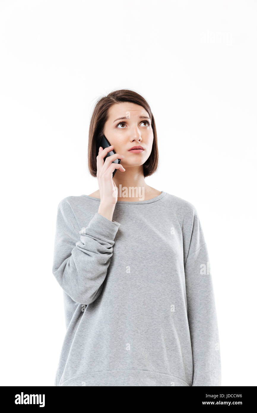 Picture of sad young caucasian woman standing isolated over white wall ...