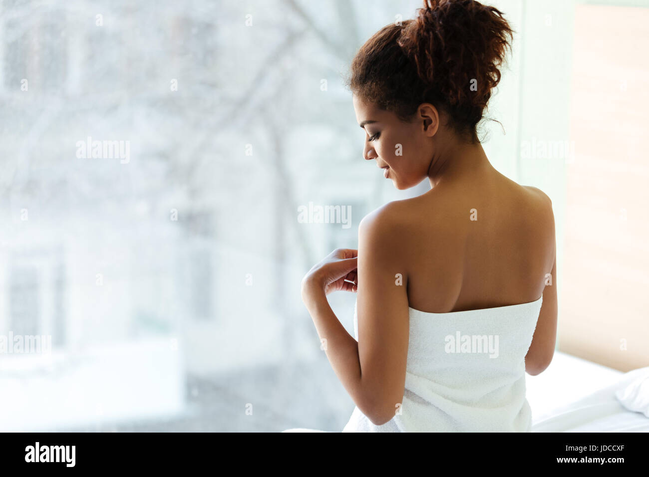 Woman standing window in towel hi-res stock photography and images - Alamy