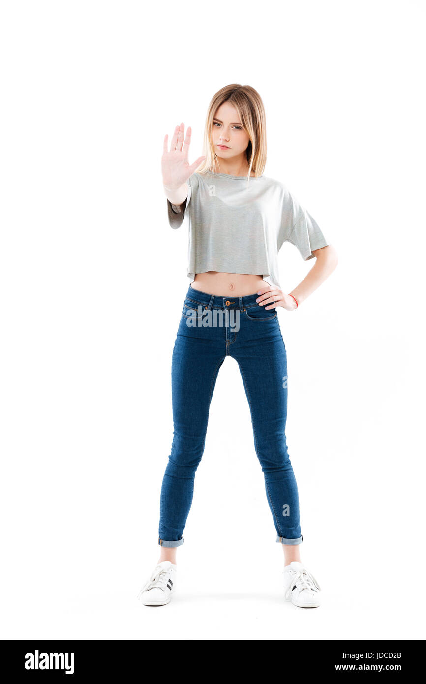 Full length portrait of a serious pretty girl standing showing stop ...