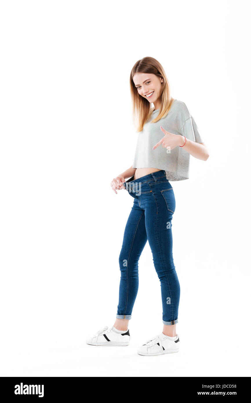 Full length portrait of a happy joyful girl showing her weight loss ...