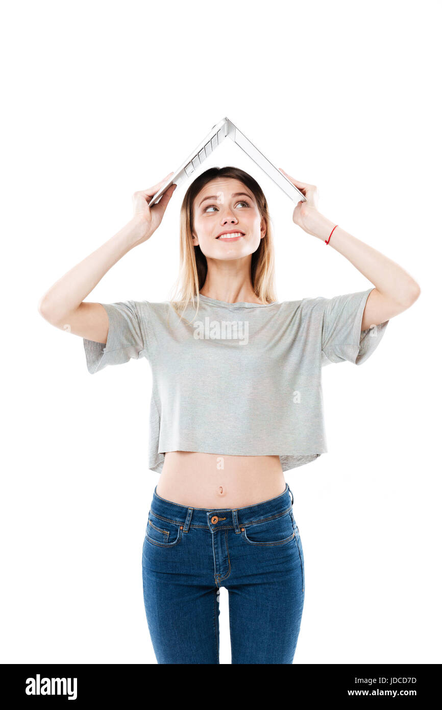 Young funny blonde woman hiding with laptop computer isolated over ...