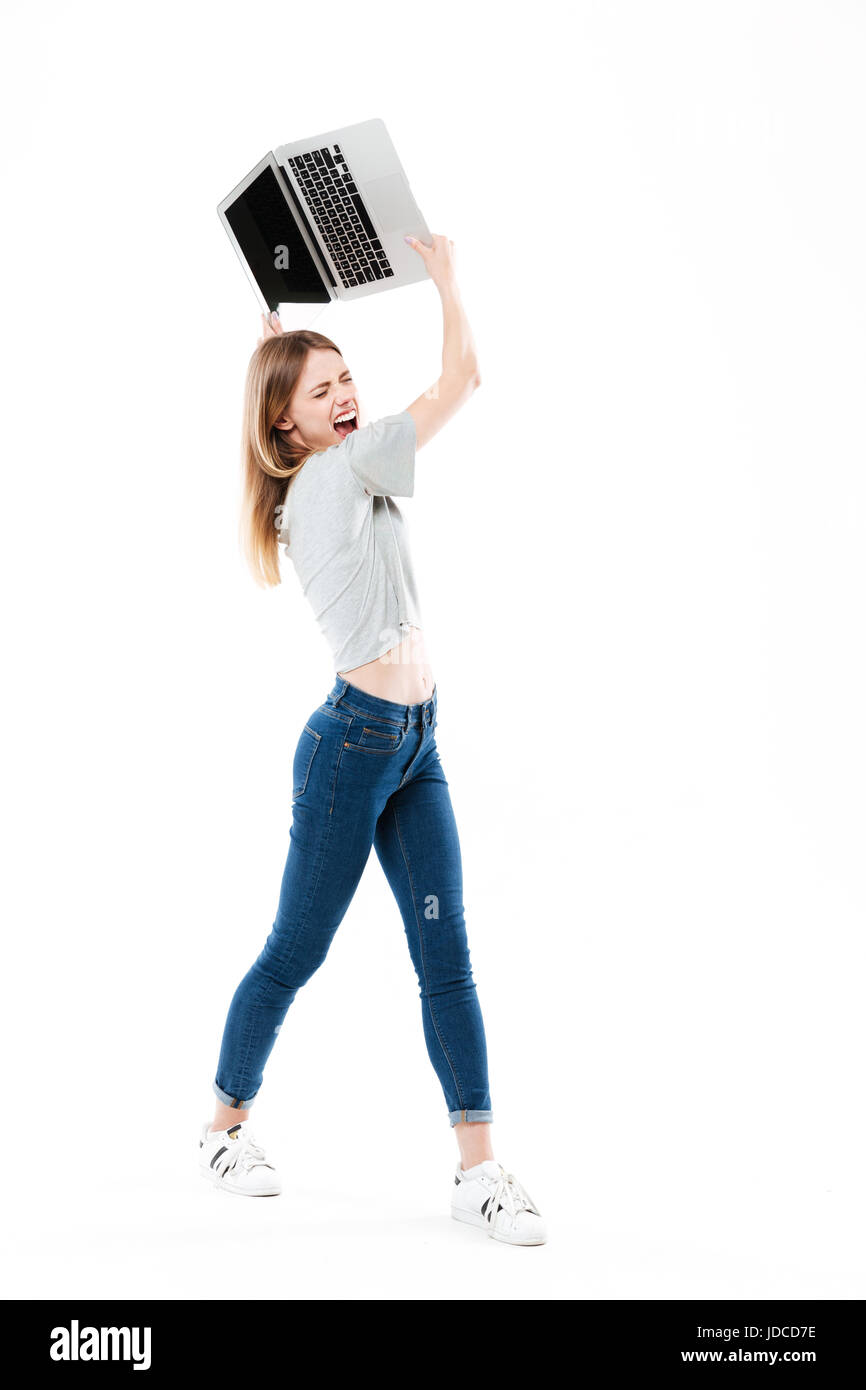 Angry blonde woman want to throw and break a laptop computer isolated ...