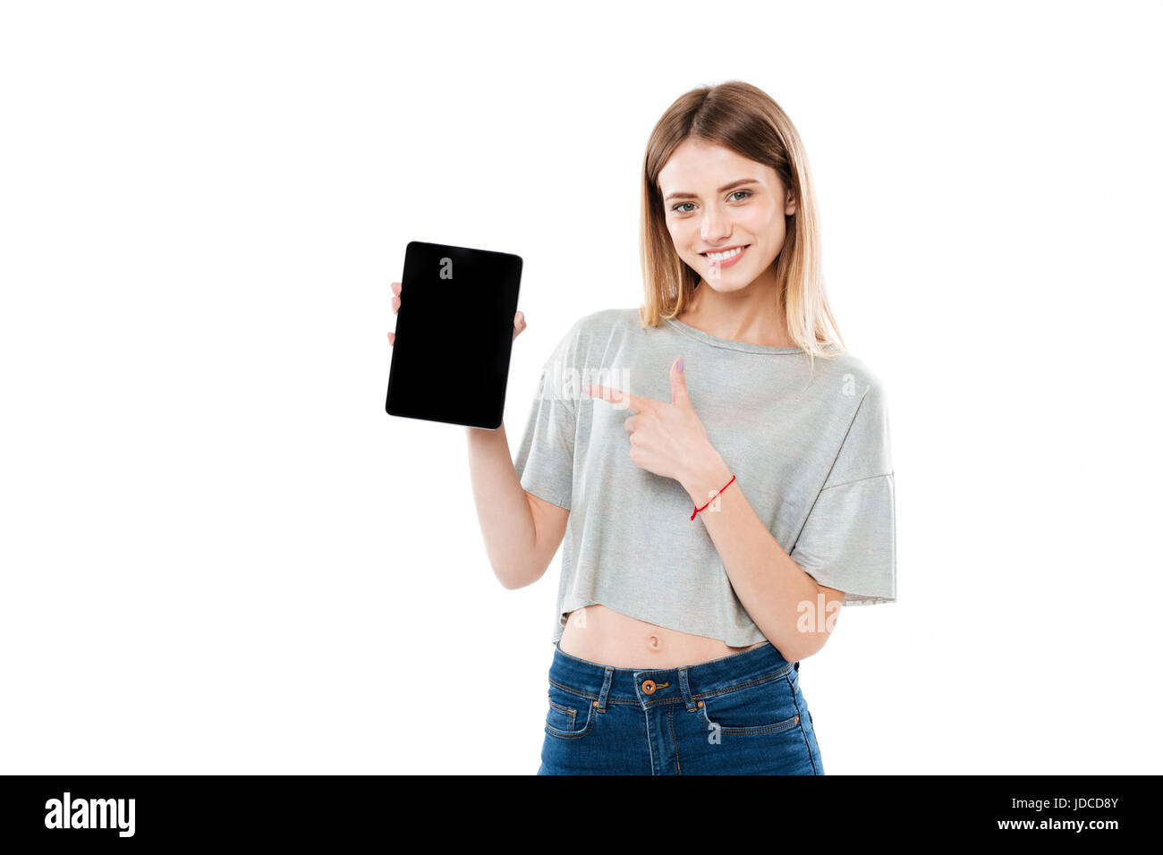 Portrait of a smiling attractive girl pointing finger at black screen ...