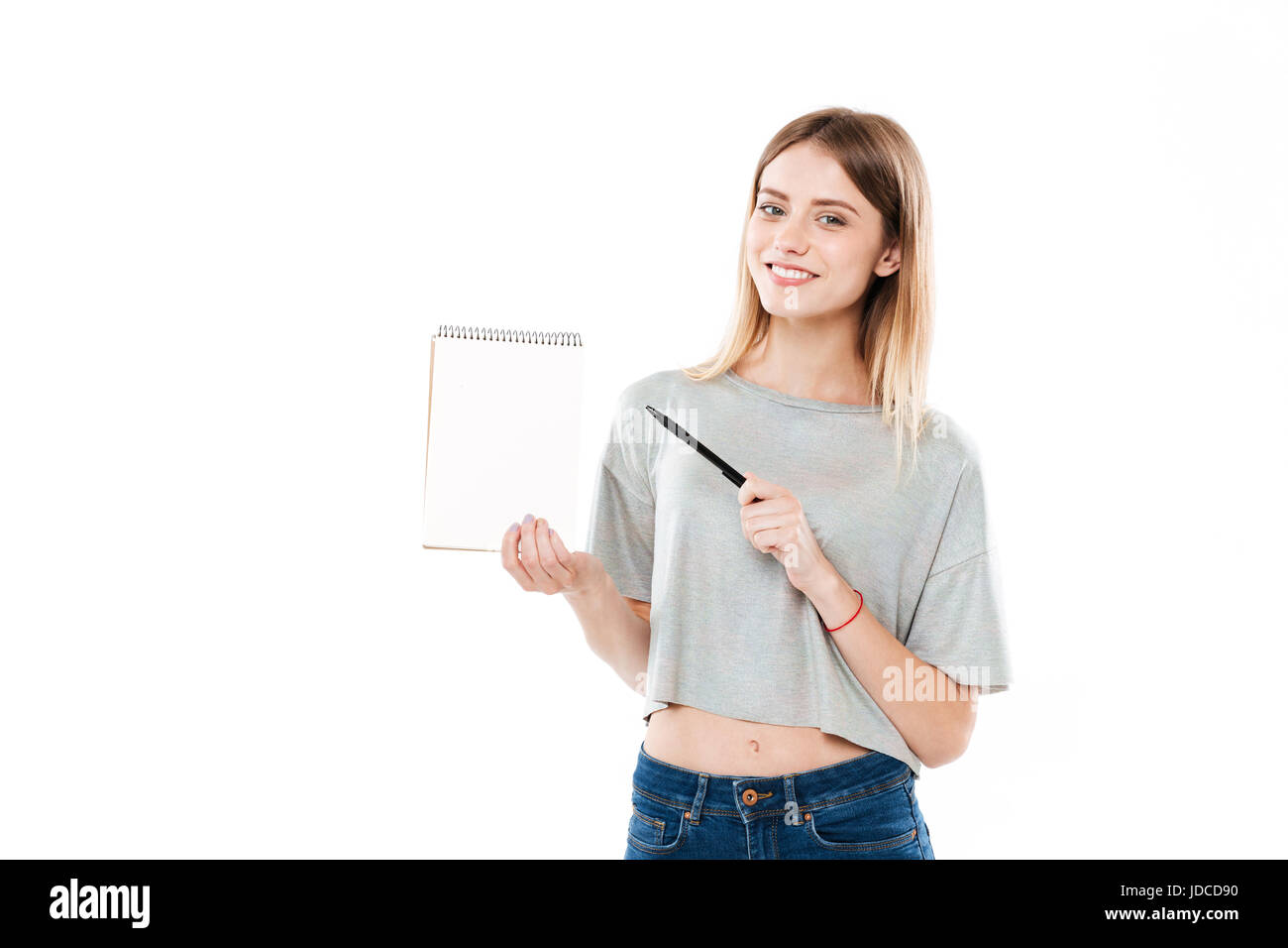 Portrait of a smiling pretty girl pointing pen on a blank paper ...
