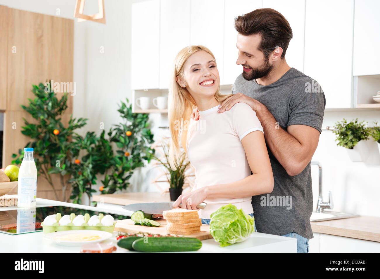 Handsome man cooking with his girlfriend at home in the kitchen Stock ...