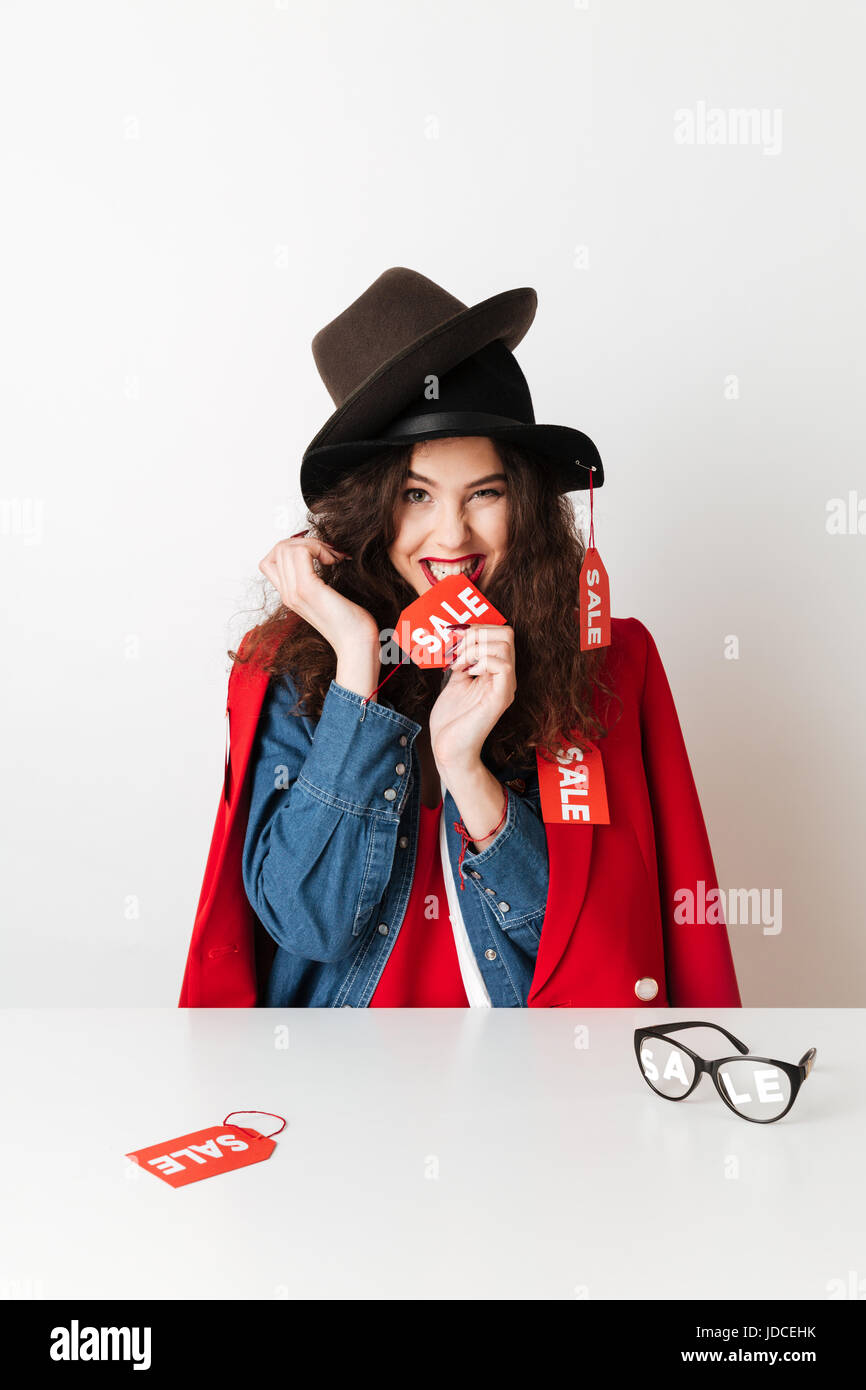 Happy sale shopping lady wearing sale signs looking at camera isolated ...