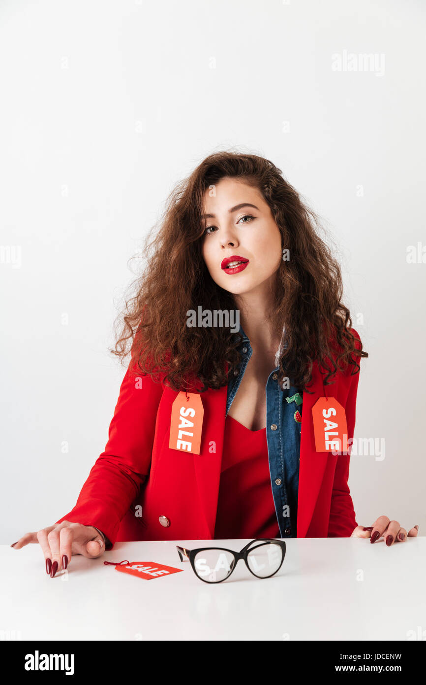 Pretty modern girl wearing clothes with sale signs and looking at ...