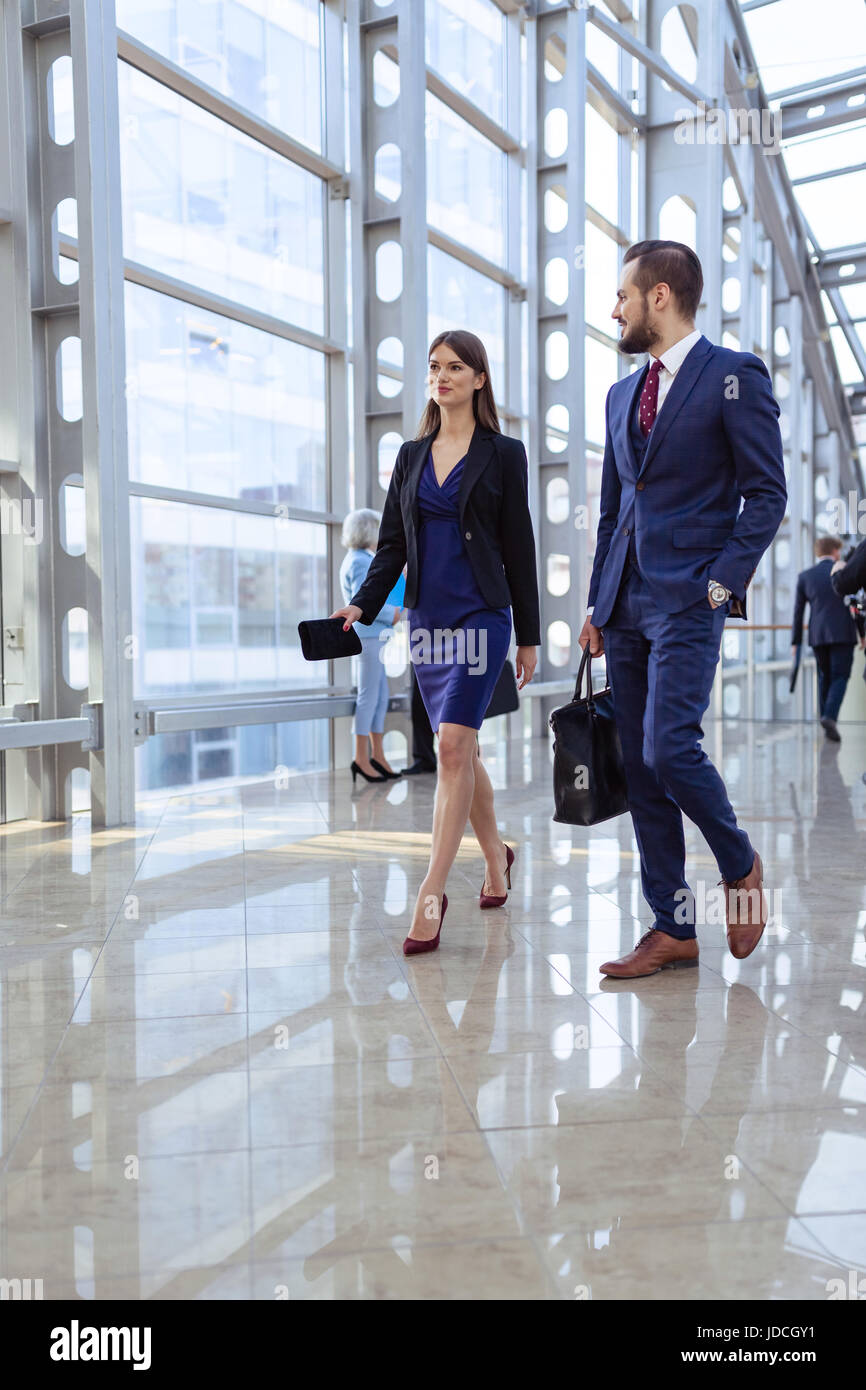 Business people walking in modern glass office corridor Stock Photo - Alamy