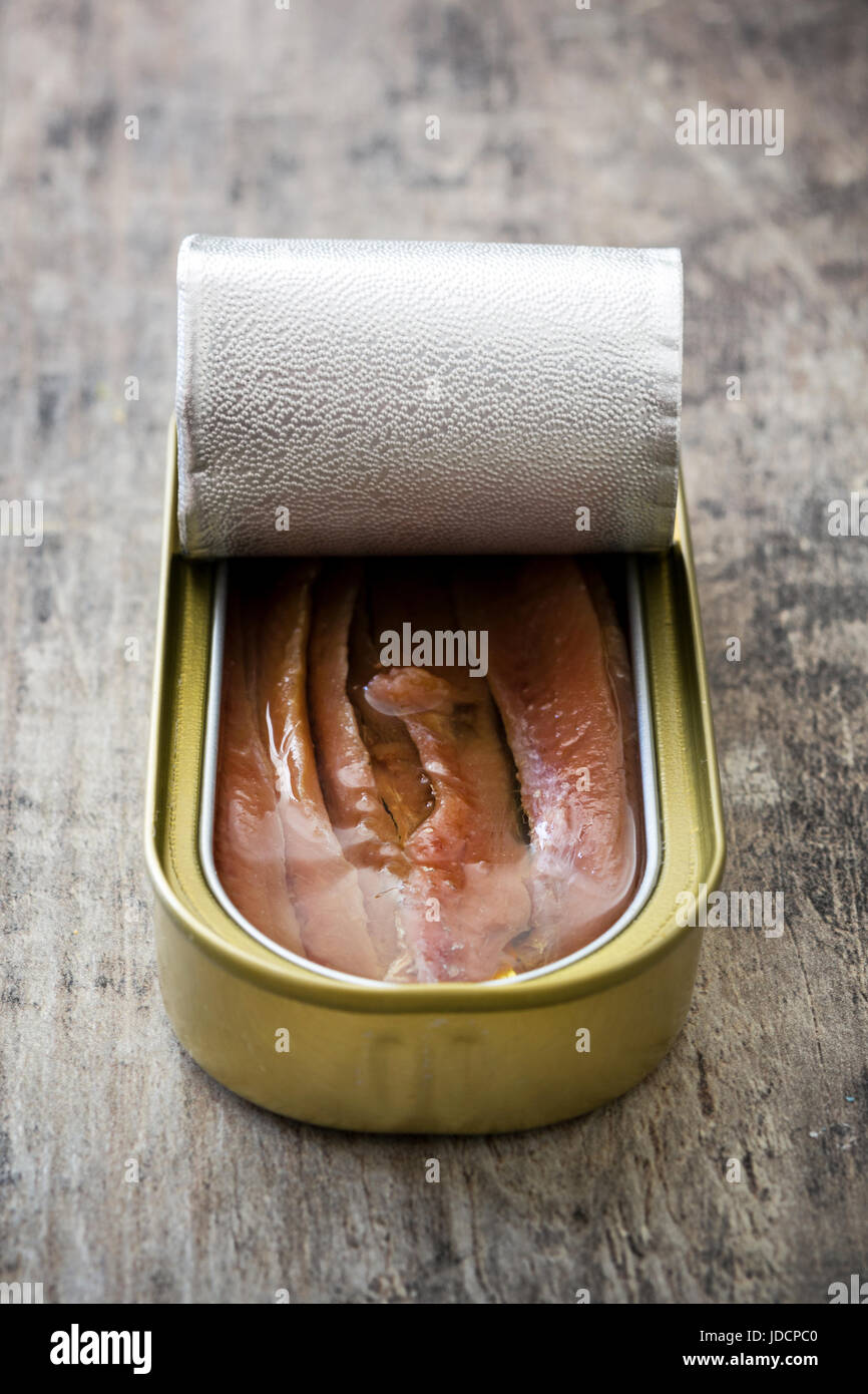 Anchovies can on wooden table Stock Photo - Alamy