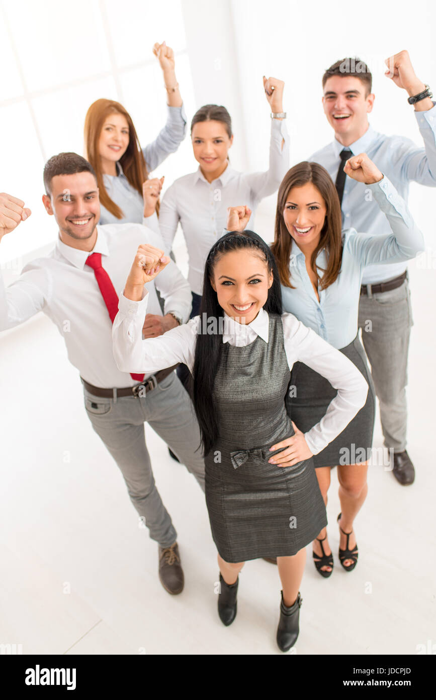 Group of young successful business people standing proudly with fist up ...