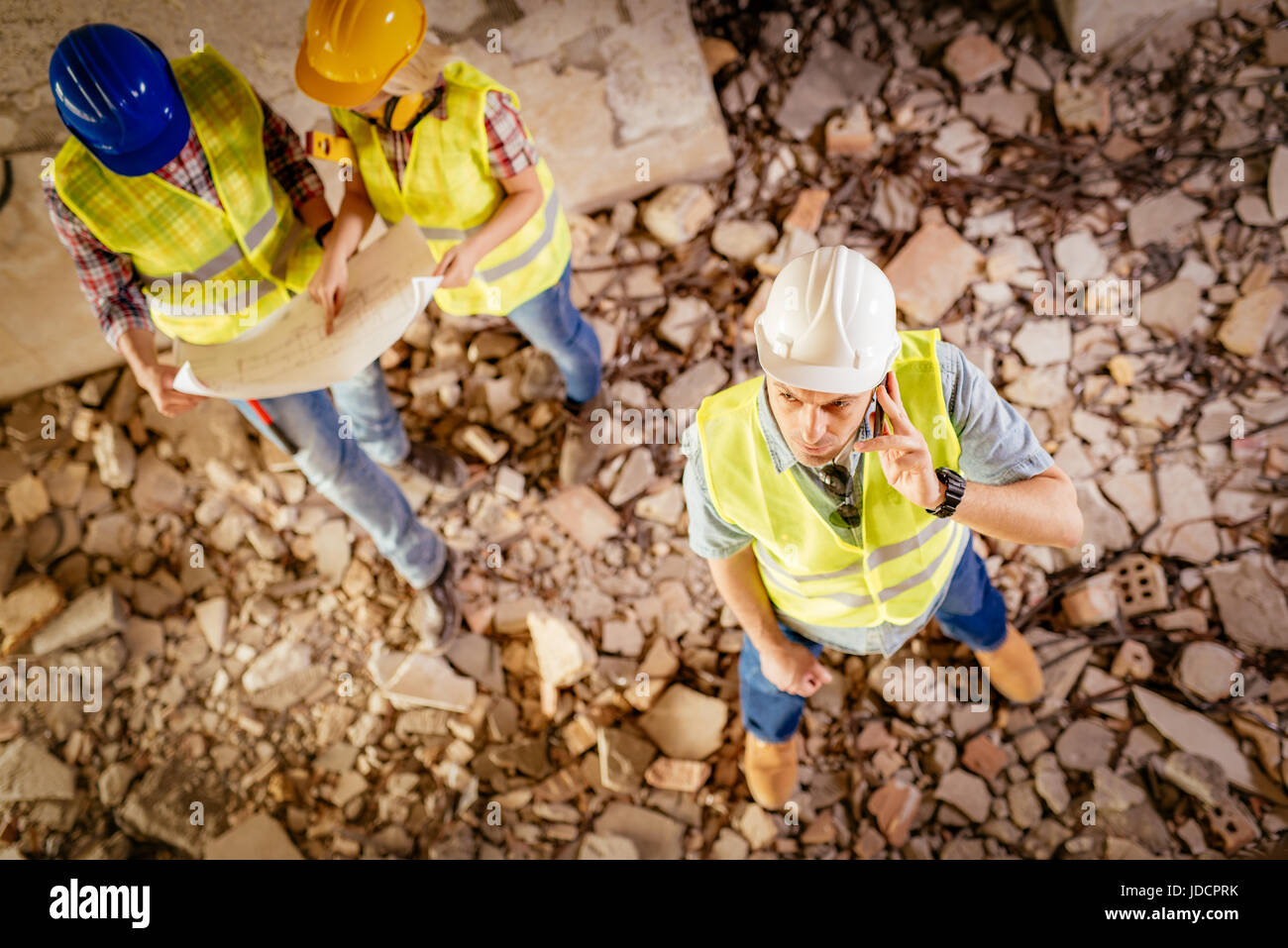 Construction architects using phone in building damaged in the disaster ...