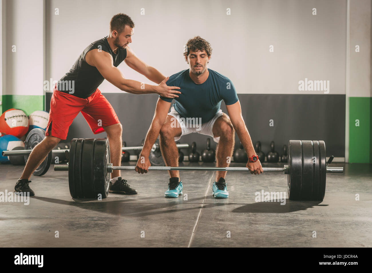 Young man doing crossfit workout with a personal trainer Stock Photo ...