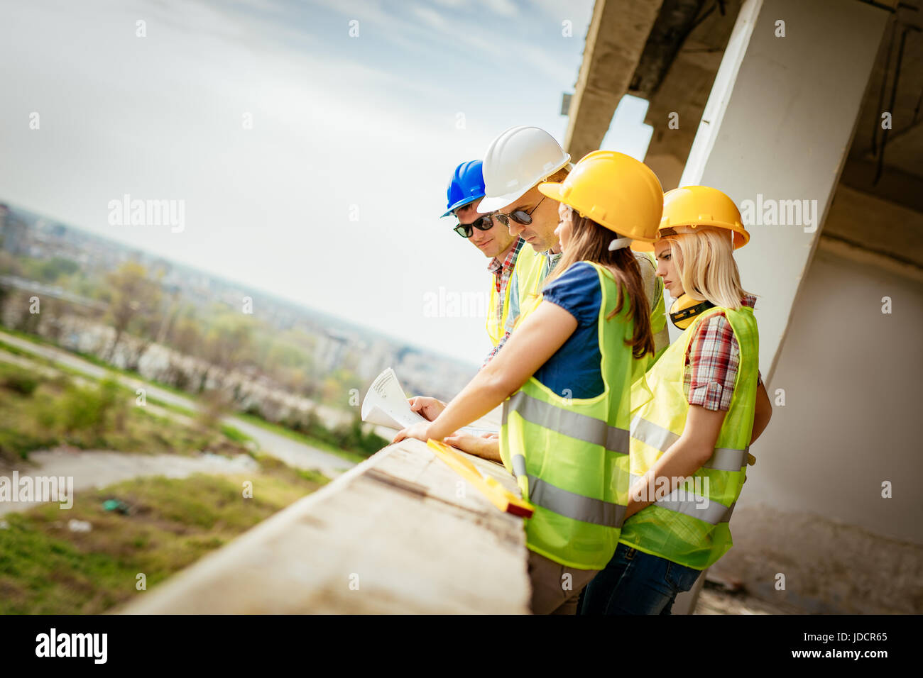 Four construction architects review plan at a construction site Stock ...