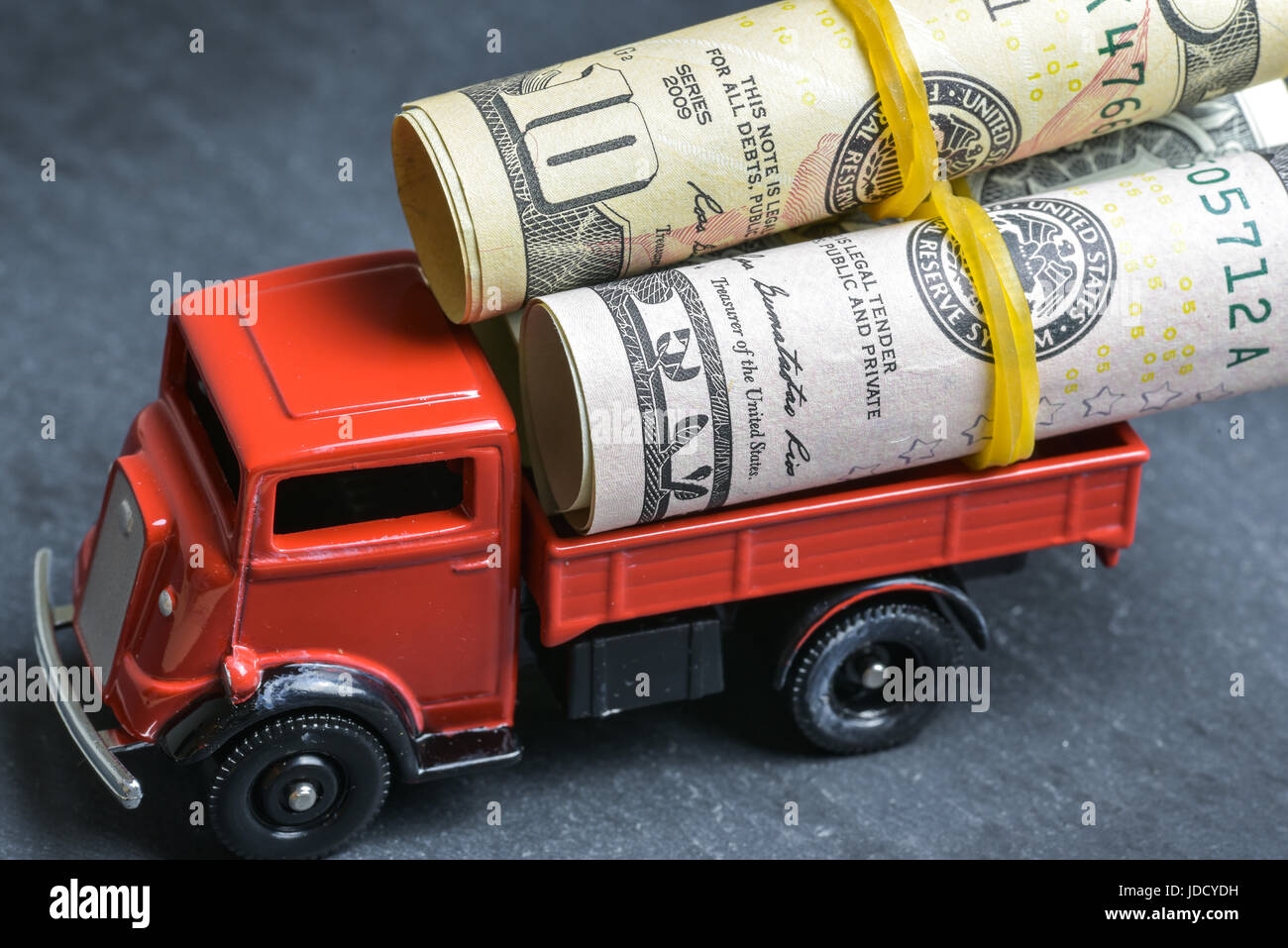 The toy red lorry with coins in a body on a stone background Stock ...
