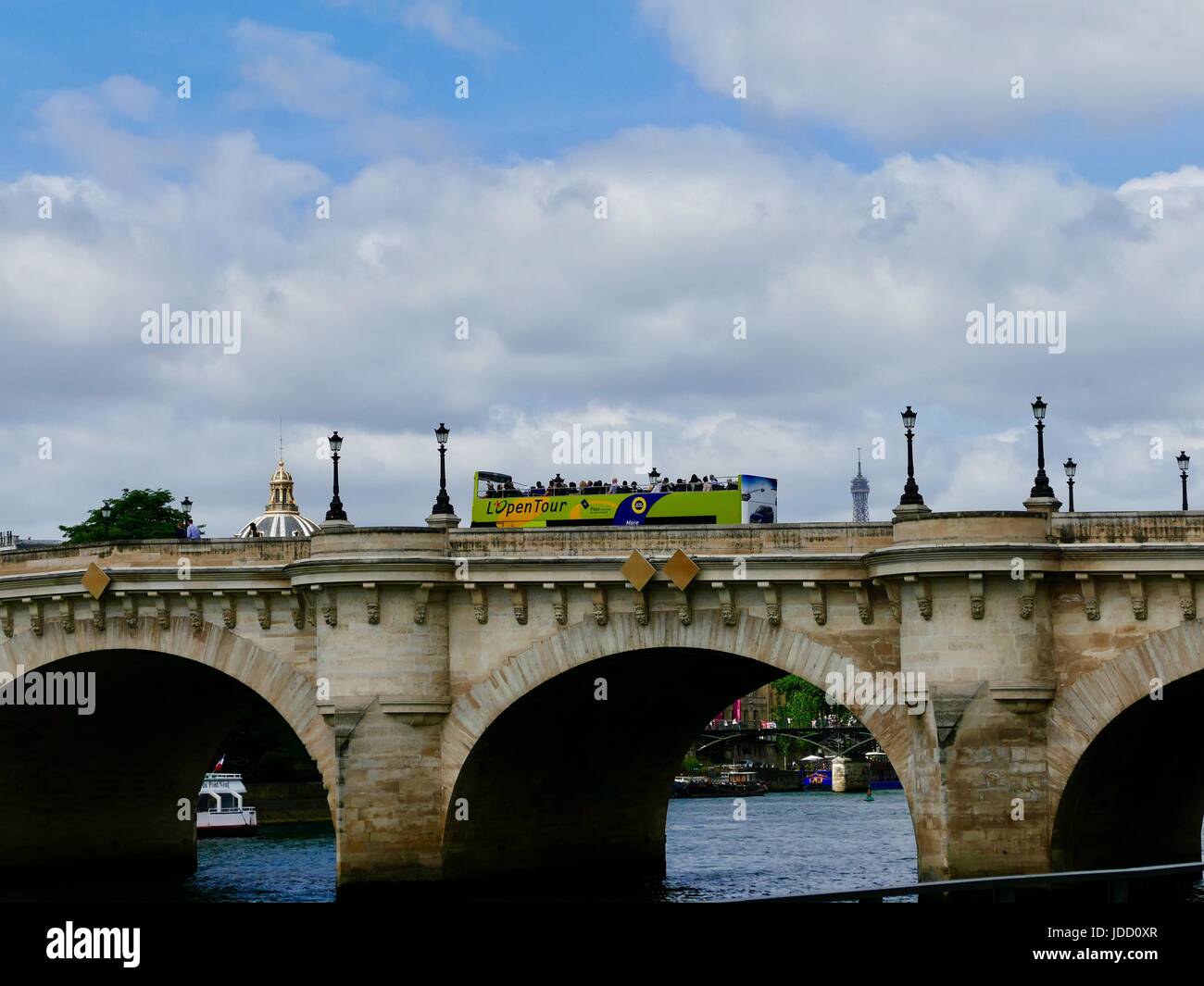 Open top tourist bus crossing Pont Neuf over the River Seine in June ...