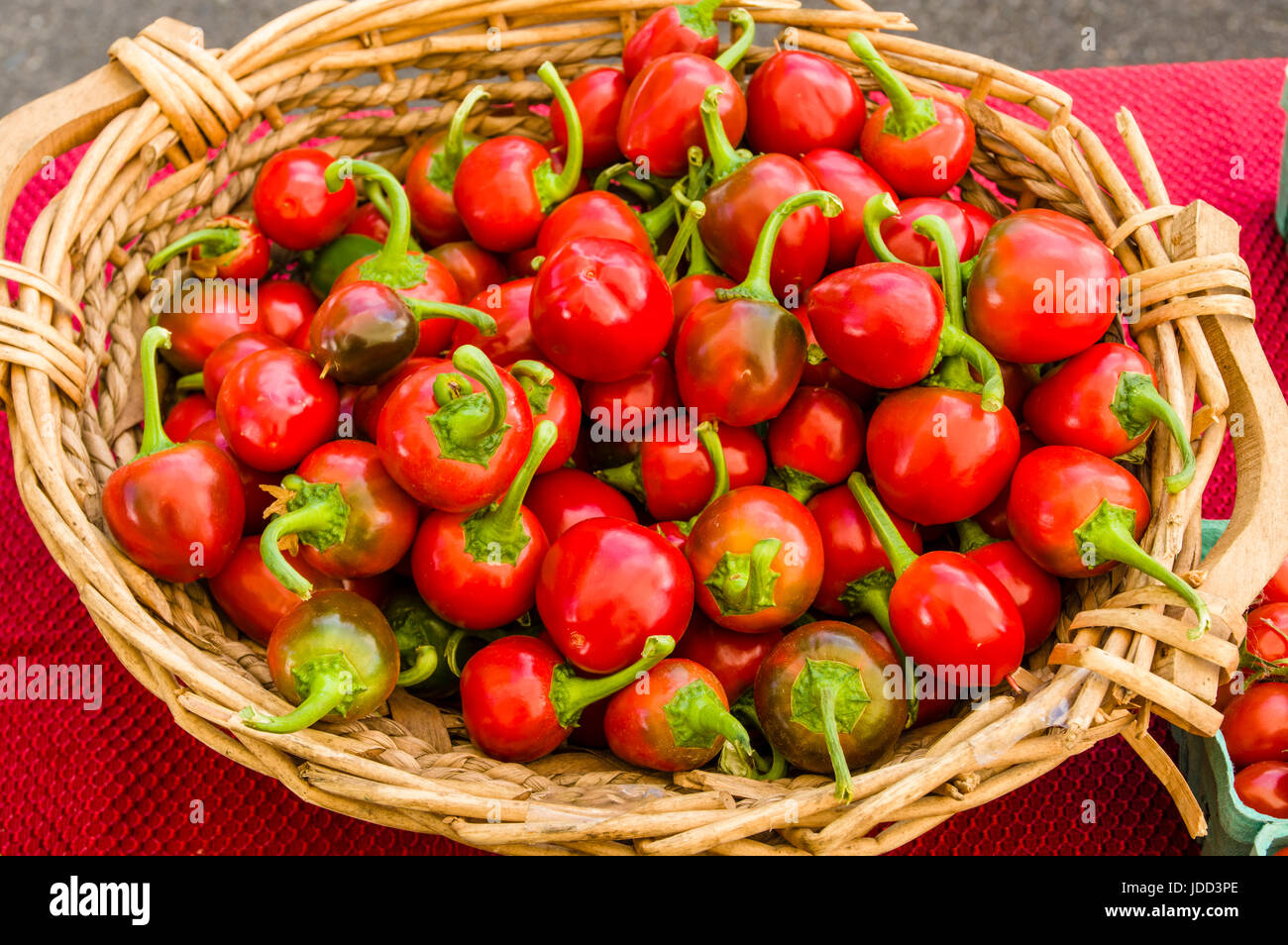 Red hot cherry peppers displayed in basket at the market Stock Photo ...