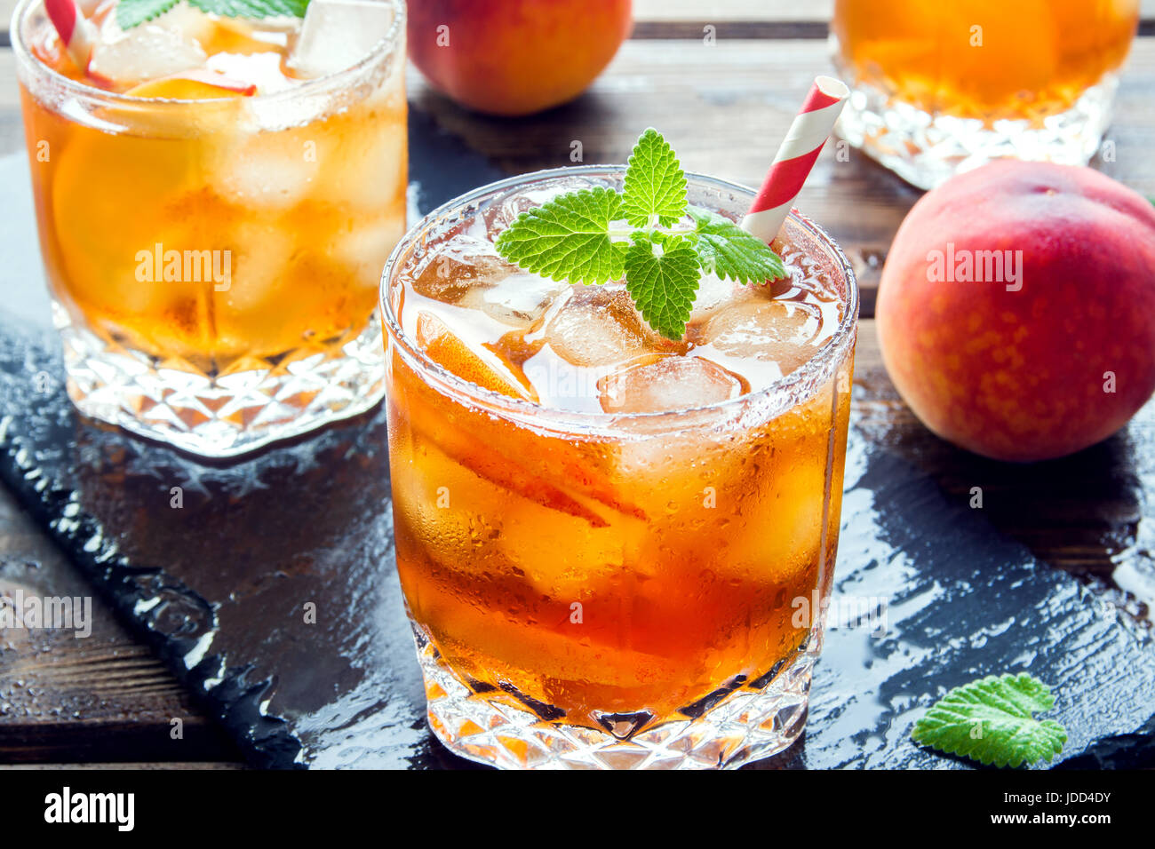 Peach iced tea. Iced tea with peach slices, mint and ice cubes close up ...