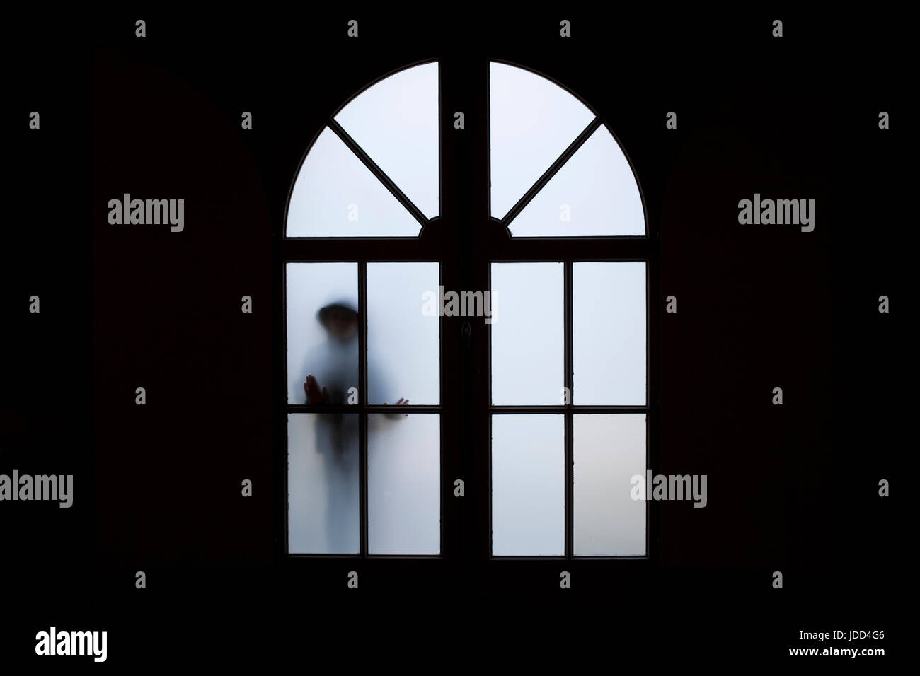 A silhouette of a child near a window inside a building Stock Photo - Alamy