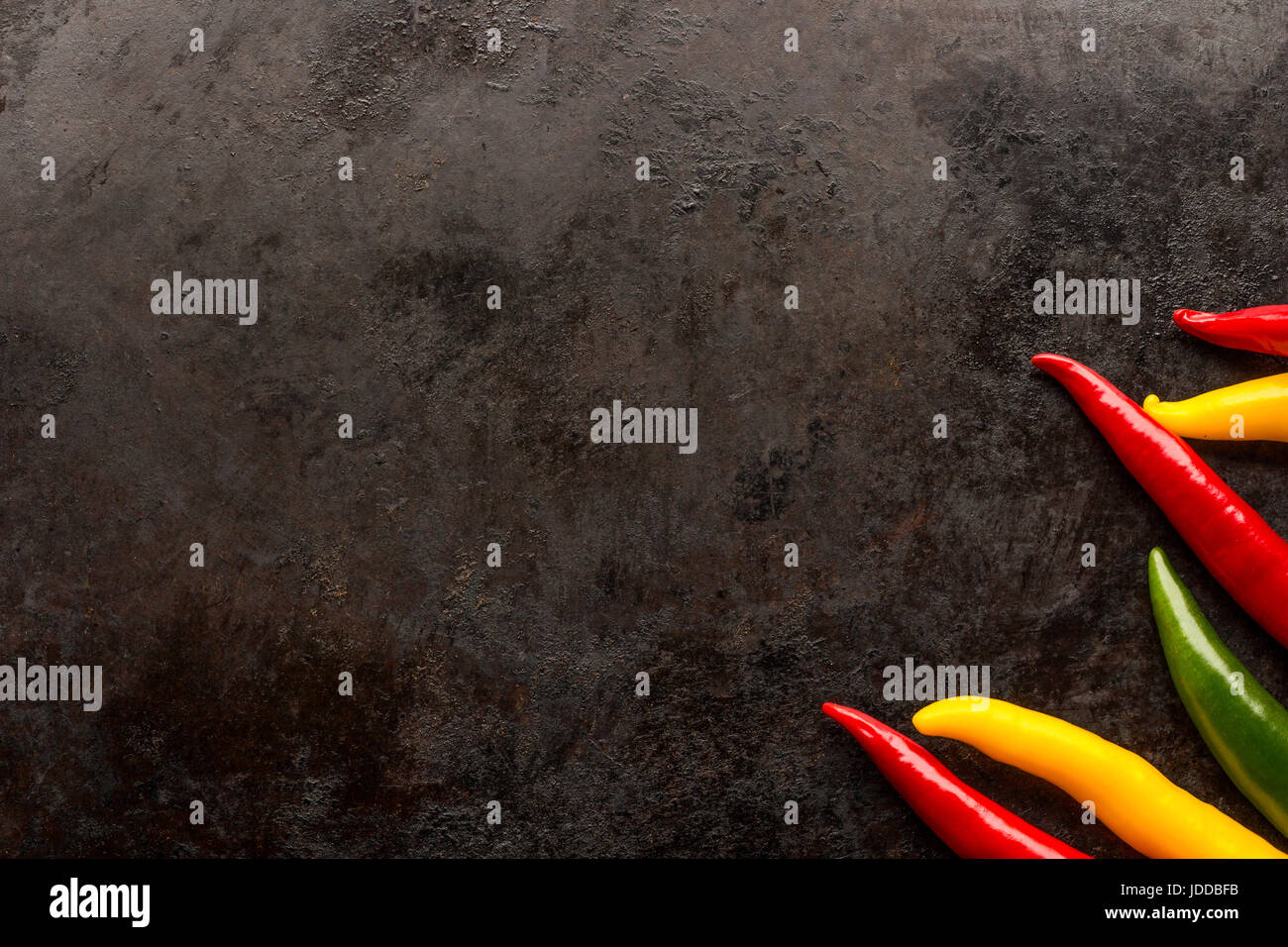 colour chilli peppers on rusty metal background Stock Photo - Alamy