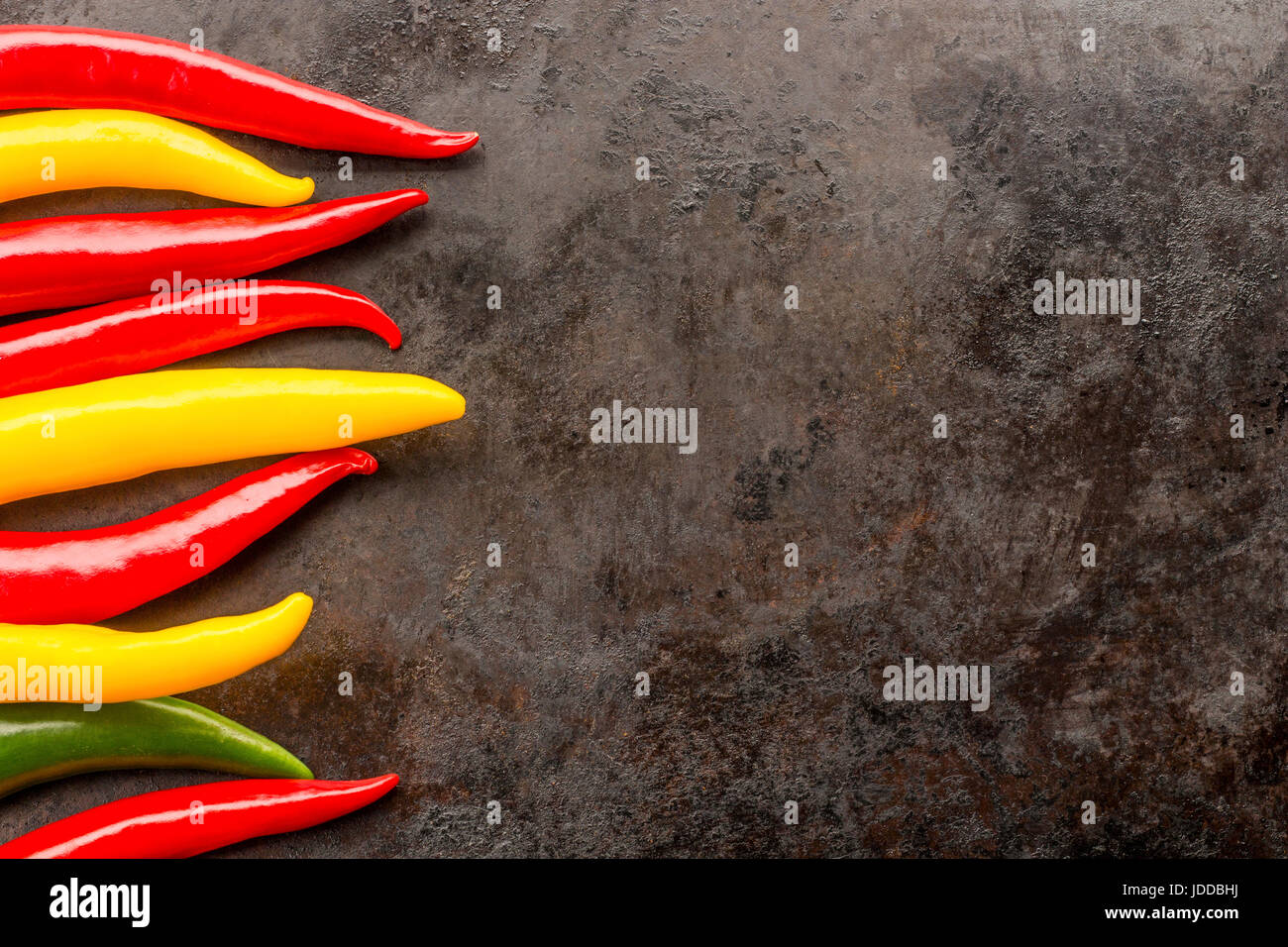 colour chilli peppers on rusty metal background Stock Photo - Alamy