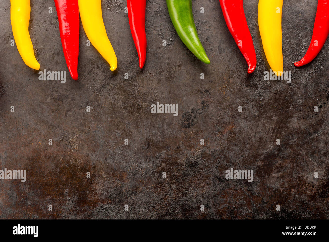 colour chilli peppers on rusty metal background Stock Photo - Alamy
