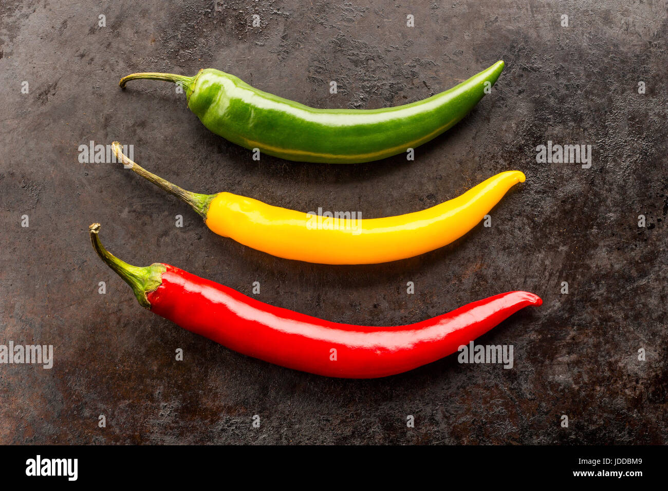 colour chilli peppers on rusty metal background Stock Photo - Alamy