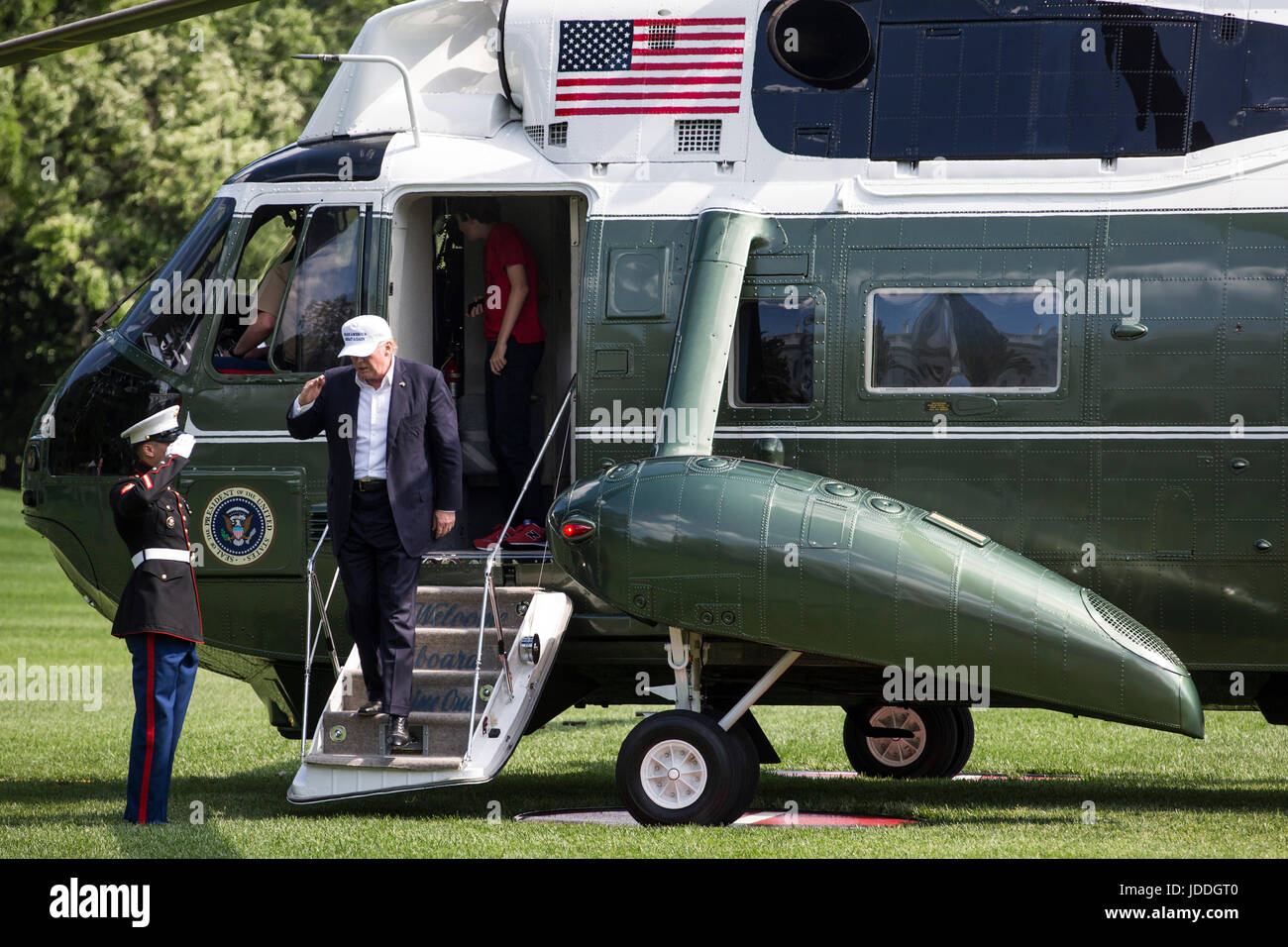 United States President Donald J. Trump salutes the Marine Guard as he ...