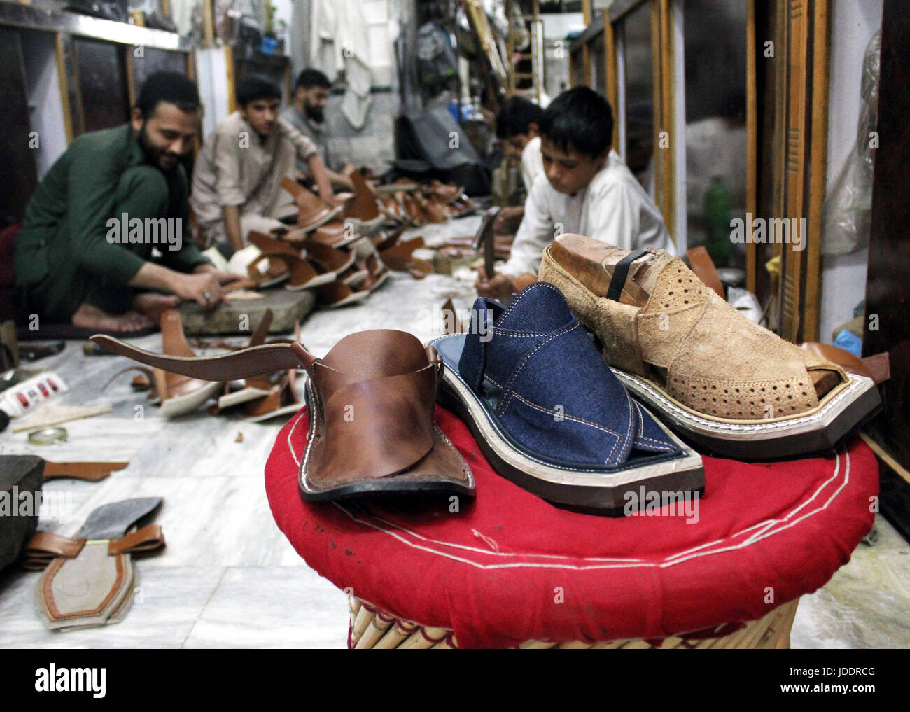 Peshawar, Pakistan. 20th June, 2017. Workers make traditional shoes ...