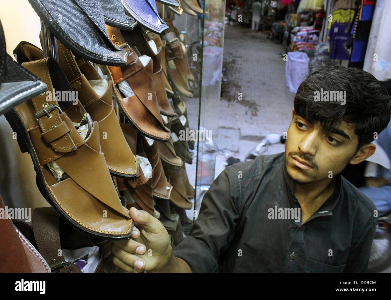 Peshawar, Pakistan. 20th June, 2017. A man selects traditional shoes ...