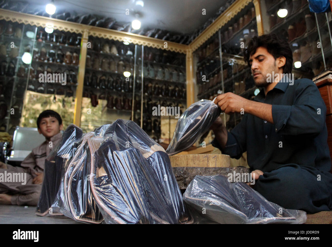 Peshawar, Pakistan. 20th June, 2017. A worker packs traditional shoes ...
