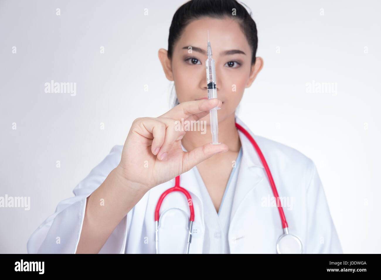Confident smiling female doctor with a syringe in hand. Portrait of a ...