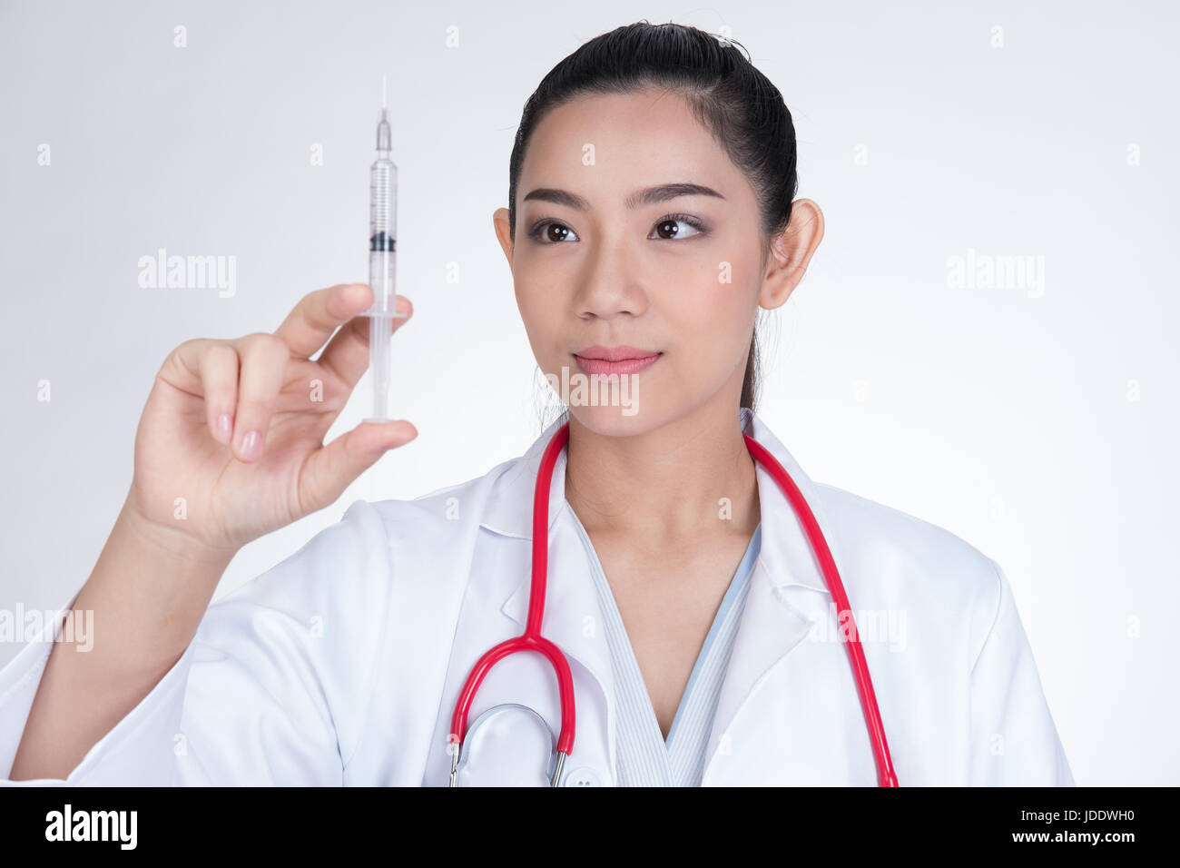 Confident smiling female doctor with a syringe in hand. Portrait of a ...