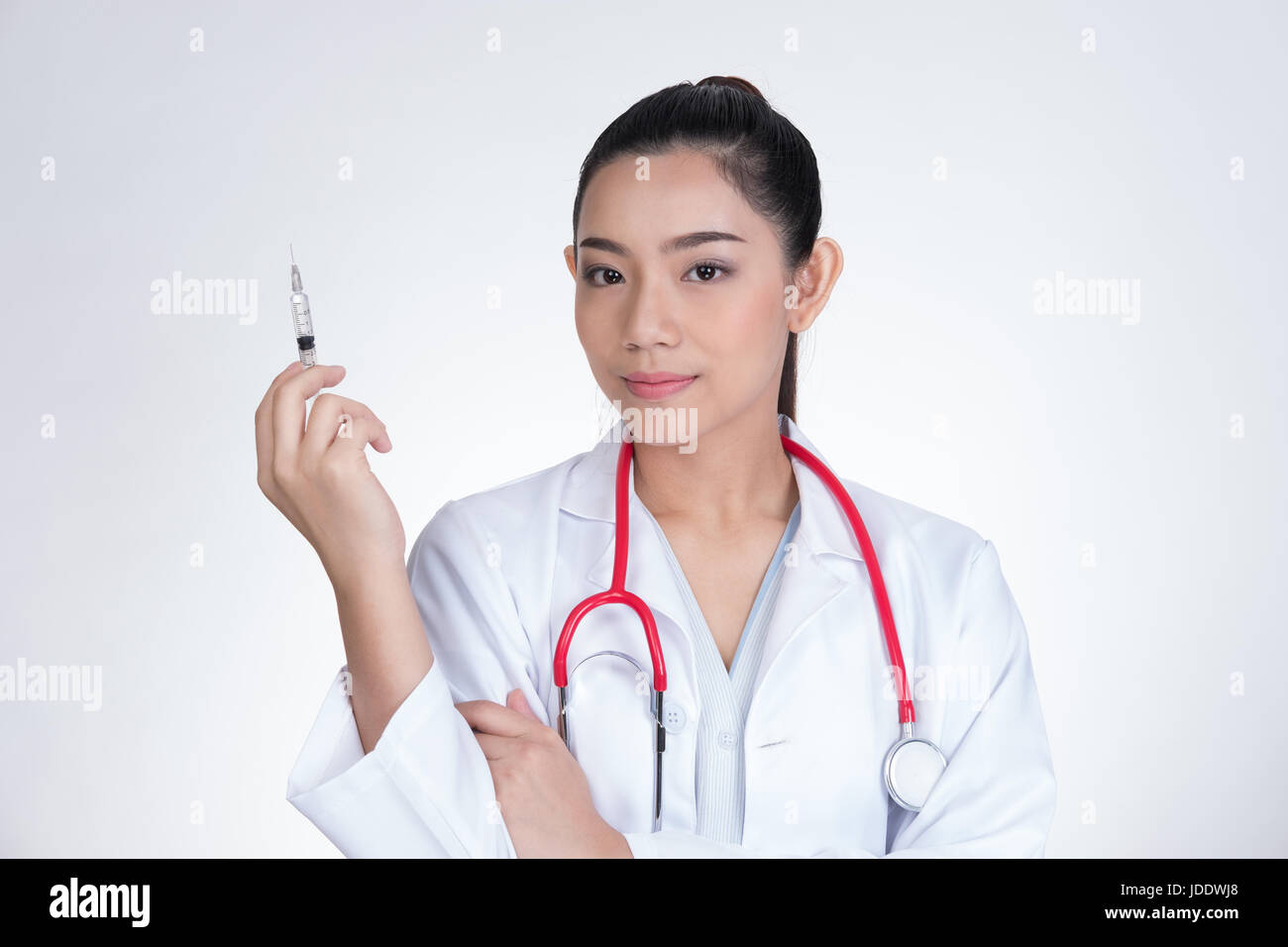 Confident smiling female doctor with a syringe in hand. Portrait of a ...