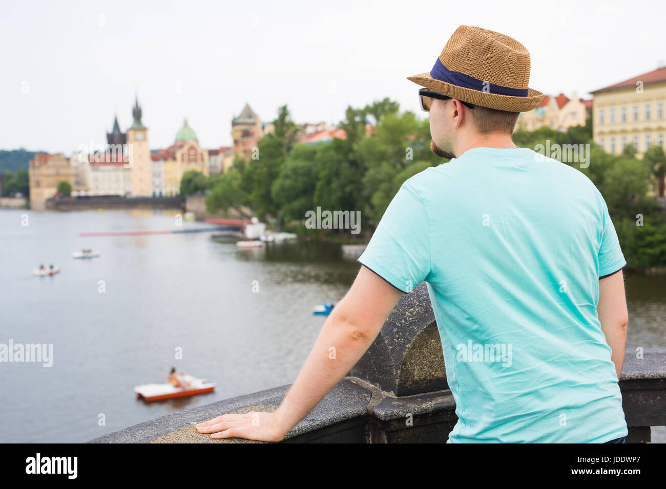 Back view of happy stylish tourist on Charles Bridge, Prague, Czech Republic. Handsome man ...
