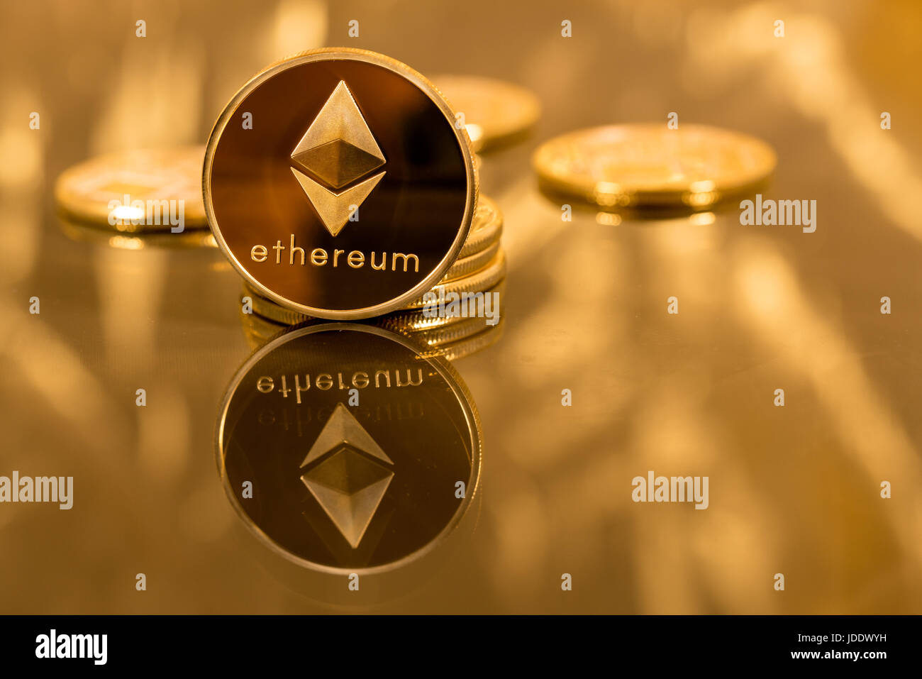 Stack of ethereum coins with gold background Stock Photo - Alamy