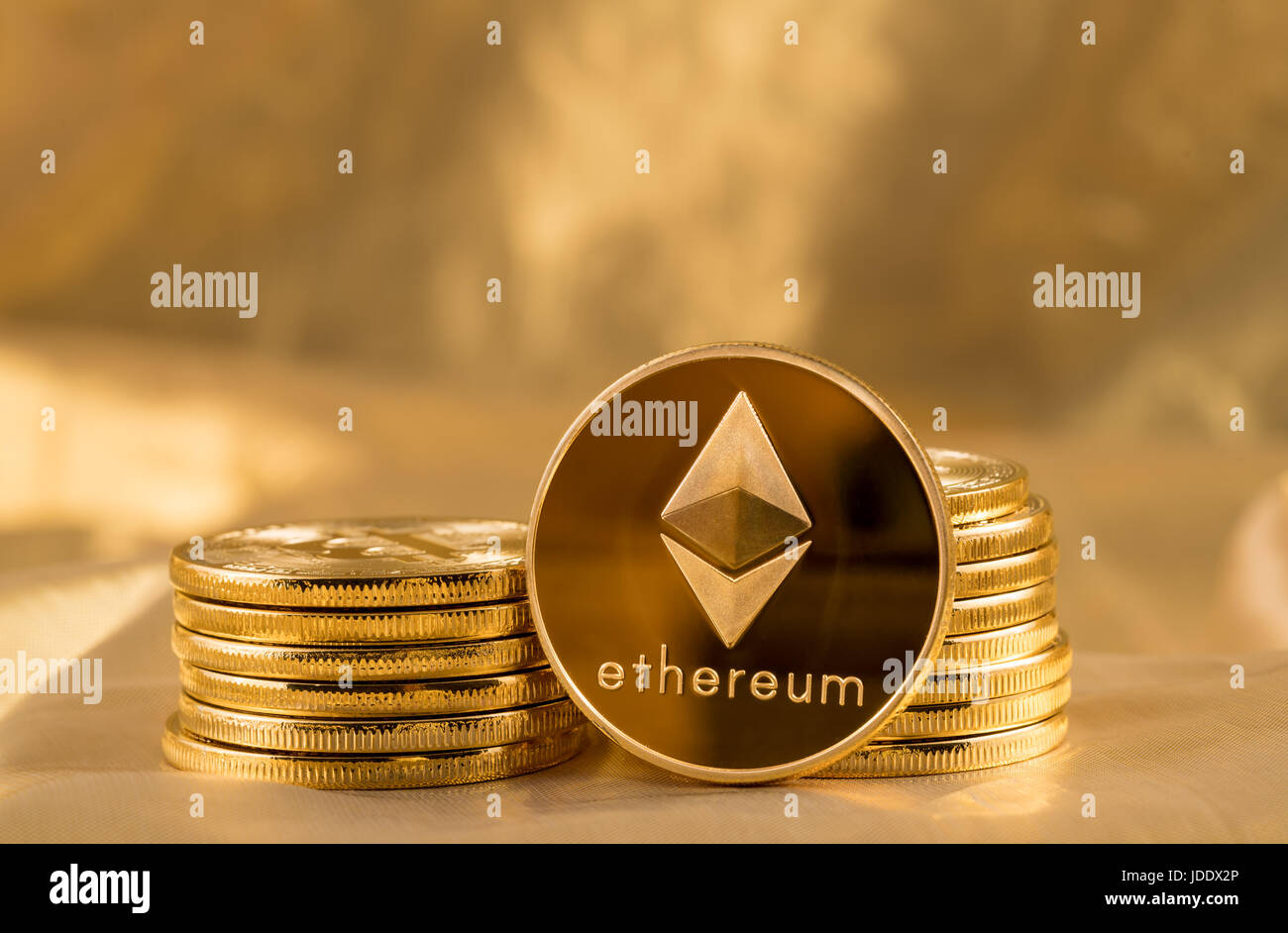 Stack of ethereum coins with gold background Stock Photo - Alamy