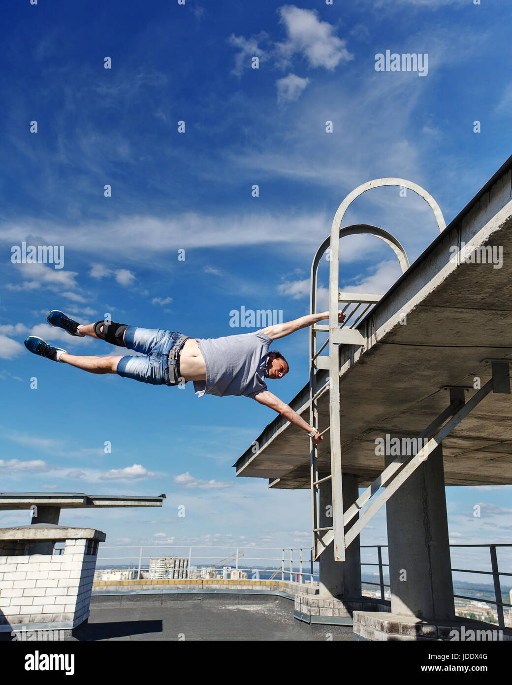 Roofer does an acrobatic stunt on the stairs. Human strength Stock ...