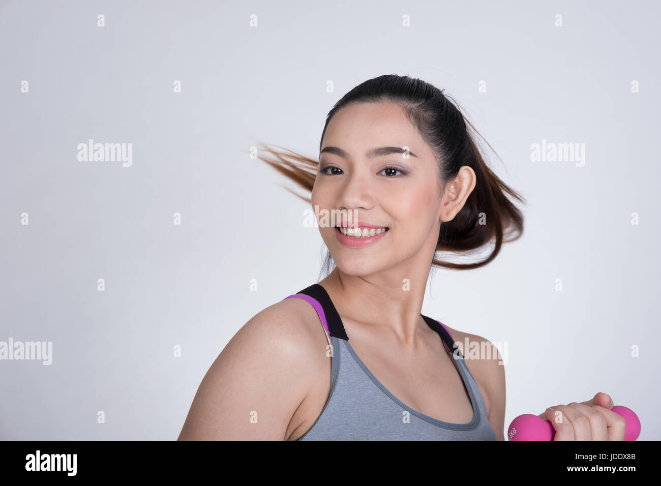 Young beautiful asian sporting woman training with dumbbell. Pretty ...