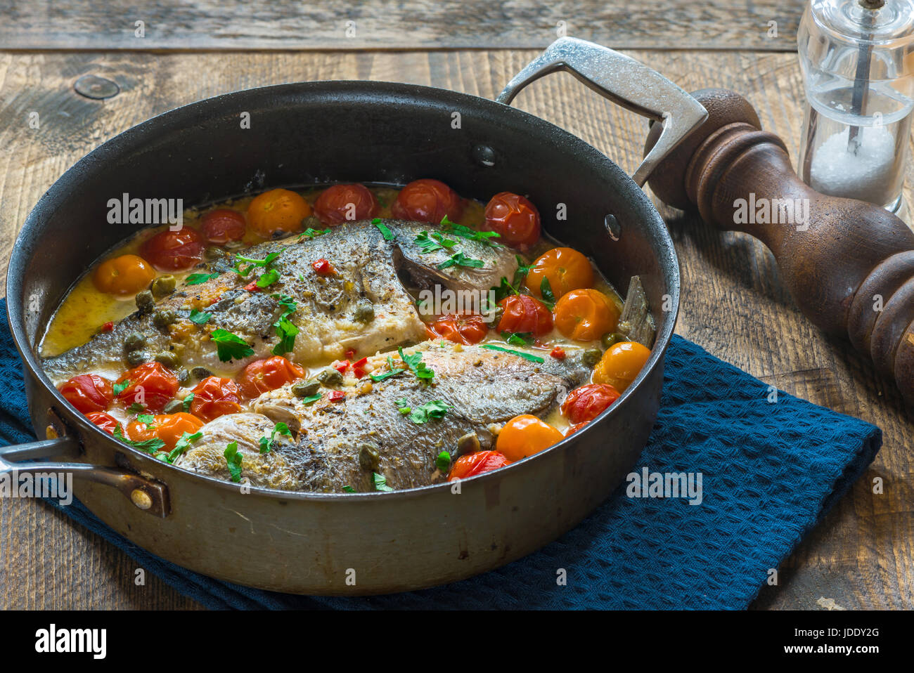 Italian style sea bream in crazy water - acqua pazza - on wooden table ...