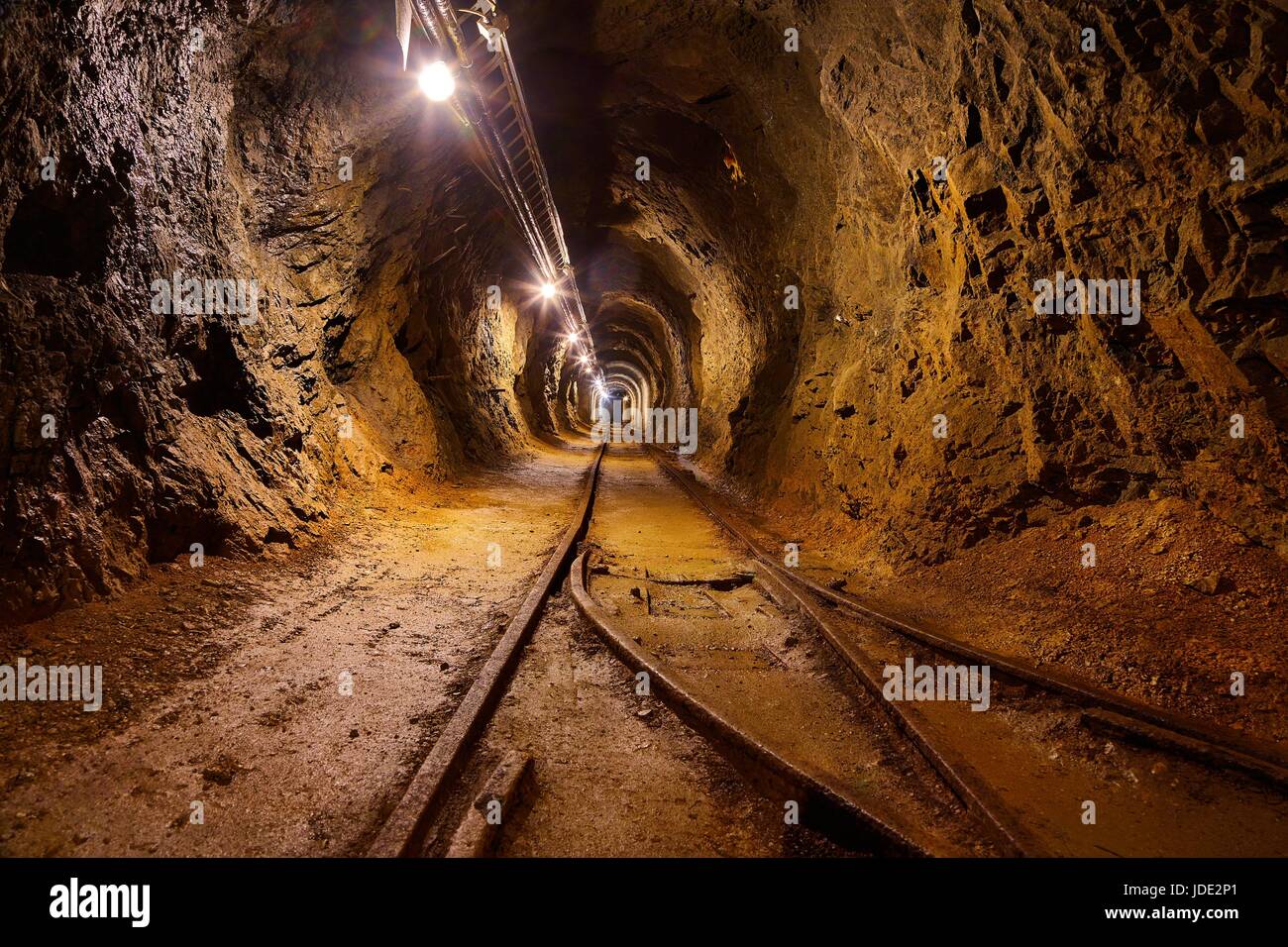 Mining tunnel with lights and rails Stock Photo - Alamy