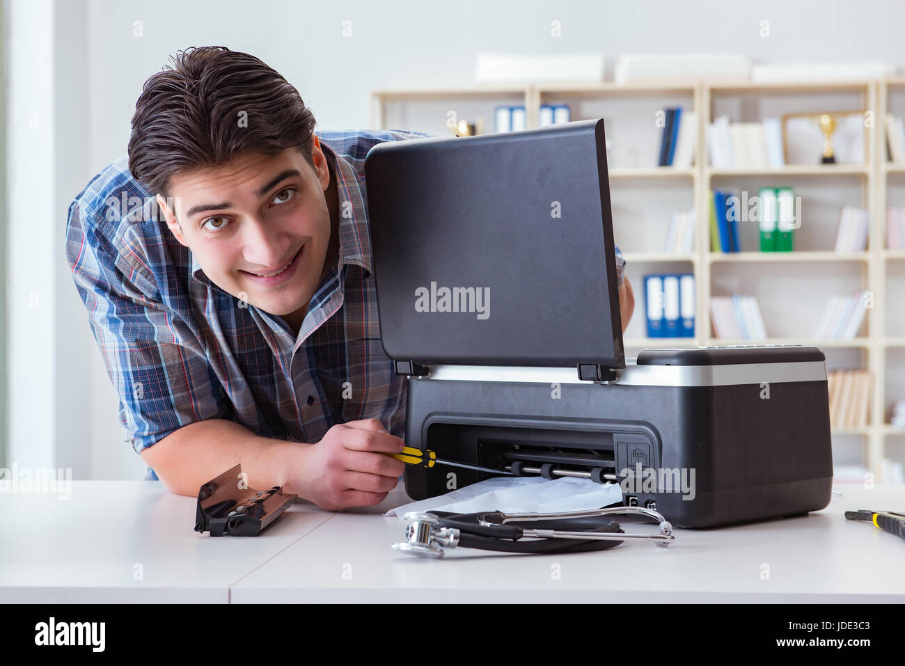 Repairman repairing broken color printer Stock Photo - Alamy