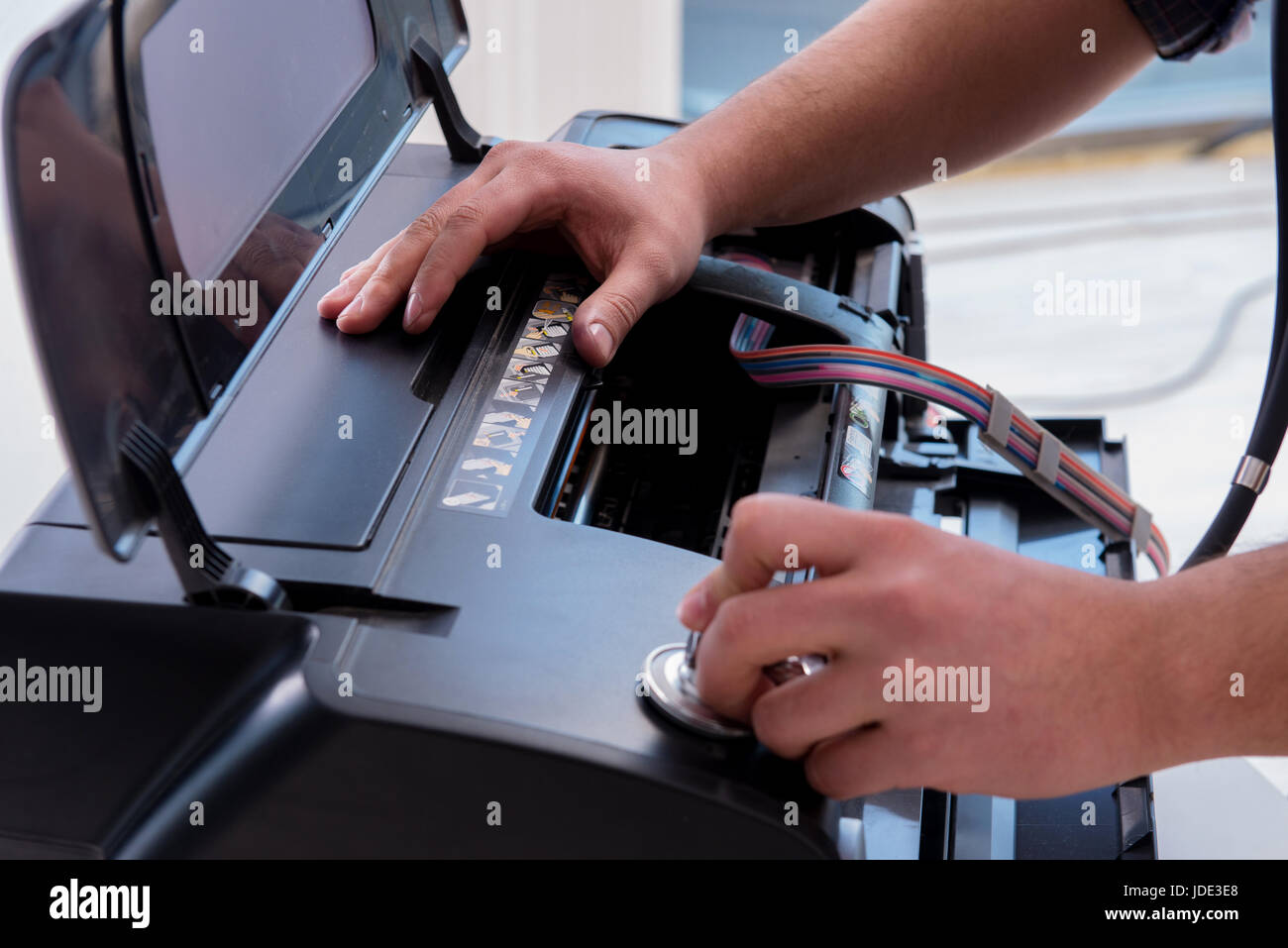 Repairman repairing broken color printer Stock Photo - Alamy