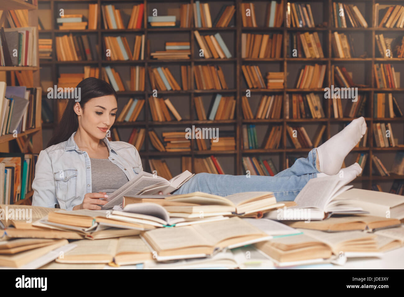Young female study in the library reading book Stock Photo - Alamy