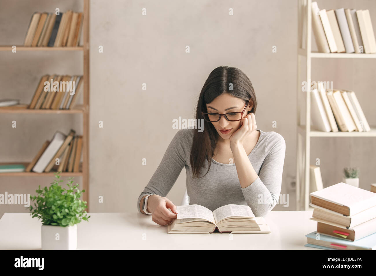 Young woman study at home alone reading a book Stock Photo - Alamy
