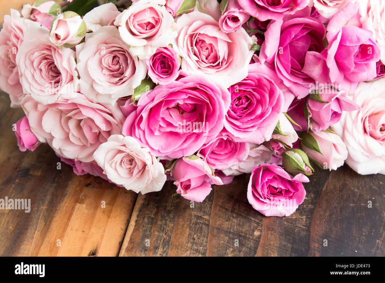 Bouquet of Pink Roses on a Rustic Wooden Background Stock Photo - Alamy