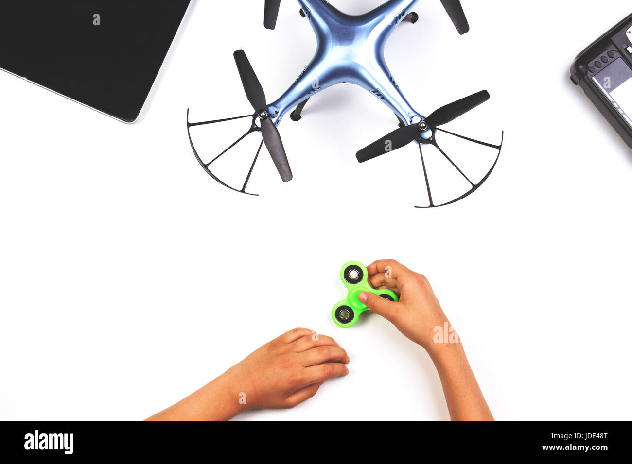 Kids hands playing with fidget spinner toy. Drone and remote controller ...